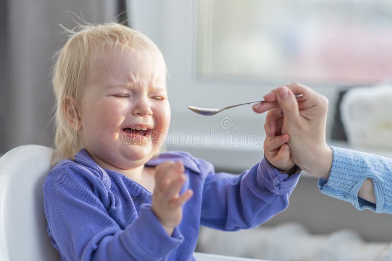 Cute Baby Refuses To Eat when Mom Feeds Her with a Spoon in the Kitchen ...