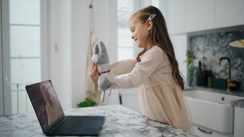 Cute Baby Showing Toy To Laptop Screen Cozy Home Closeup. Positive Girl ... Cute Baby Showing Toy To Laptop Screen Cozy Home Closeup. Positive Girl ...