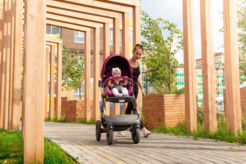 Cute Baby in a Stroller for a Walk with Her Mother Stock Photo - Image ...