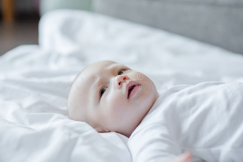 Cute Baby on White Bed. Baby Newborn Concept Stock Image - Image of ...