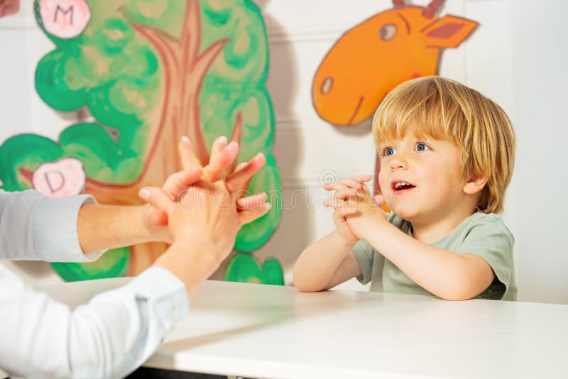 Cute Blond Boy Play Finger Game Sitting by the Desk in Class Stock ...