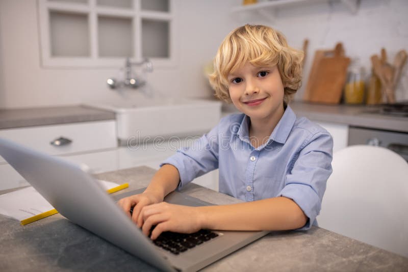 Cute Blond Boy Typing on a Laptop and Smiling Stock Image - Image of ...