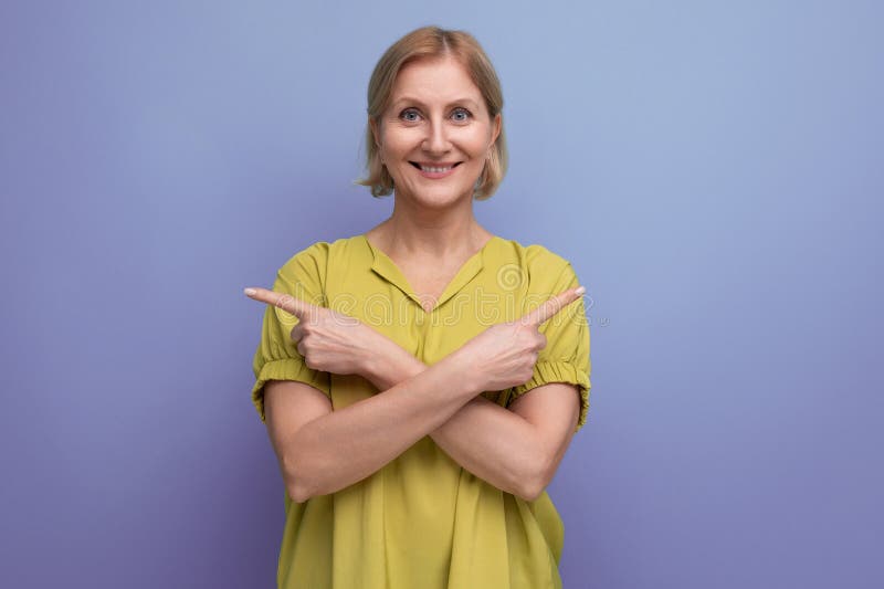 Cute Blond Middle Aged Woman with an Idea Points Her Finger To the Side in Studio Stock Photo ...