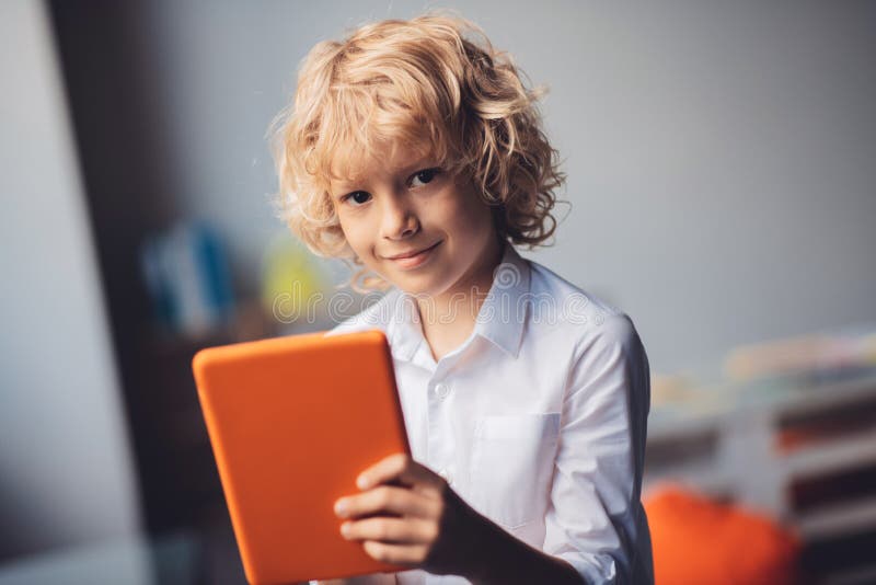 Cute Blonde Boy Holding His Tablet and Smiling Stock Image - Image of ...