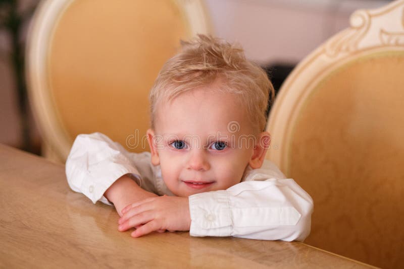 Cute Blonde Hair Little Boy is Sitting at the Table Stock Image - Image ...
