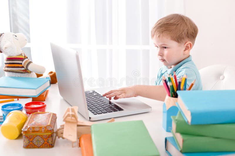 Cute Boy Absorbedly Using Laptop Stock Photo - Image of childhood ...