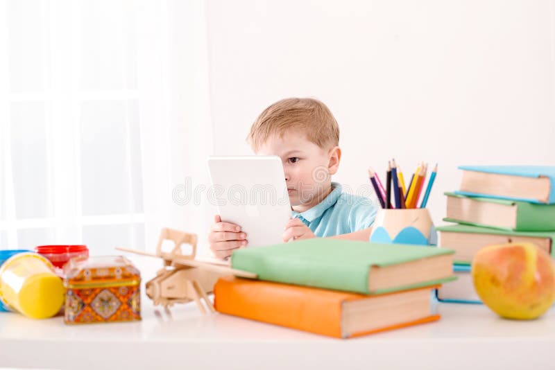 Cute Boy Absorbedly Using Tablet Computer Stock Image - Image of ...