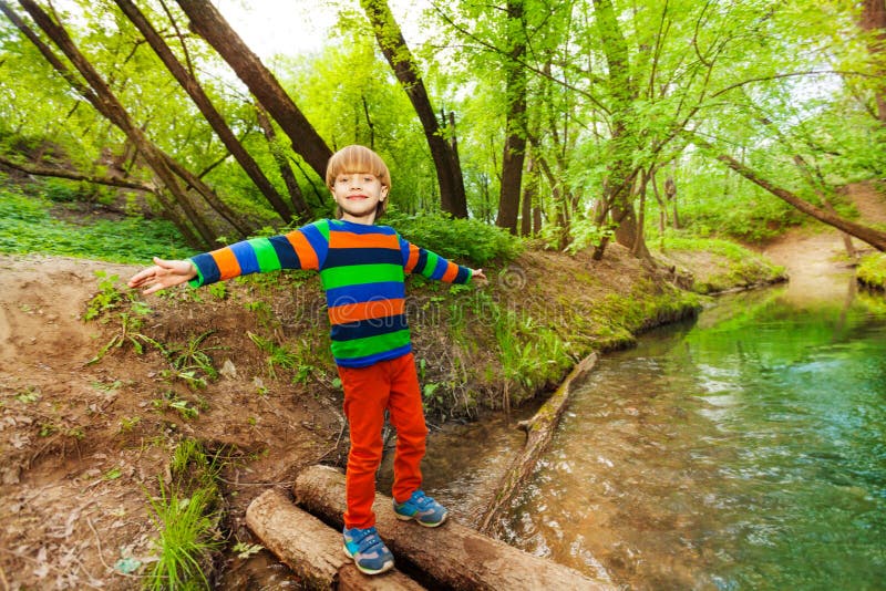 Cute Boy Balancing on a Log Bridge Over the River Stock Image - Image ...
