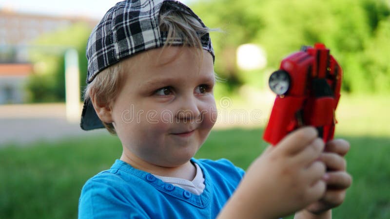 Cute Boy in a Checkered Cap with a Red Toy Car in His Hands Stock Photo ...