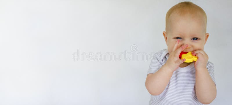 A Cute Boy is Chewing a Toy on a White Background. Teething in Children ...