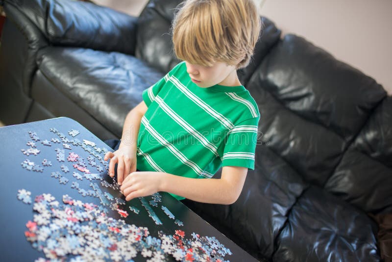 Cute boy doing a puzzle stock image. Image of assemble - 87626991