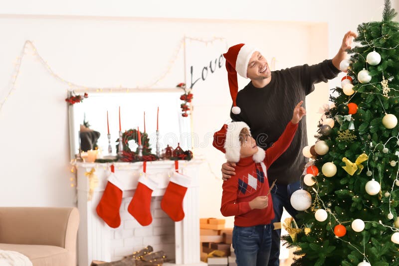 Cute Boy with Father Decorating Christmas Tree in Room Stock Photo ...