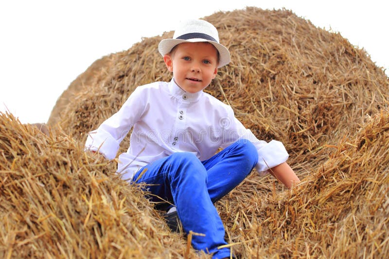 A Cute Boy is High Under the Sky on a Haystack in the Hay Season. Stock ...