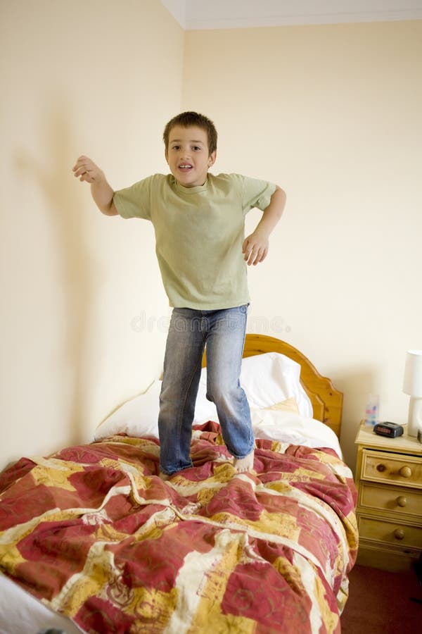 Cute boy is jumping on bed stock photo. Image of blanket - 12693332