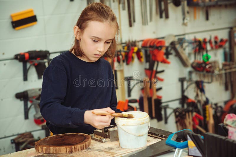 Cute Boy Makes Wooden Clock in the Workshop. Young Carpenter Working ...