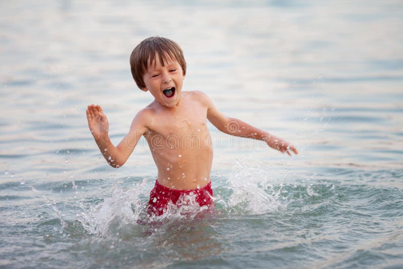 Cute Boy Playing on the Beach in the Water Stock Photo - Image of ...