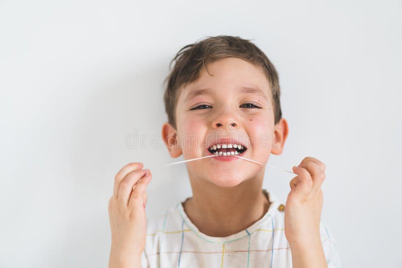 Cute Boy Pulling Loose Tooth Using a Dental Floss. Process of Removing ...