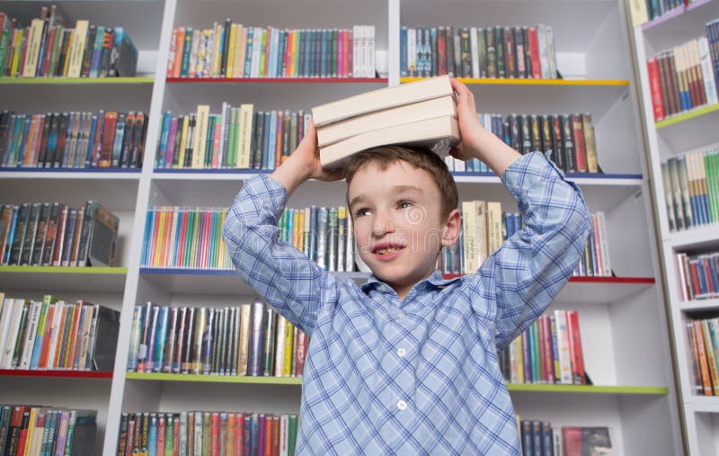 Cute Boy Reading Book in Library Stock Photo - Image of kids, desk ...