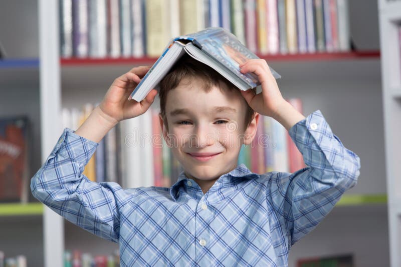 Cute Boy Reading Book in Library Stock Image - Image of child, learning ...