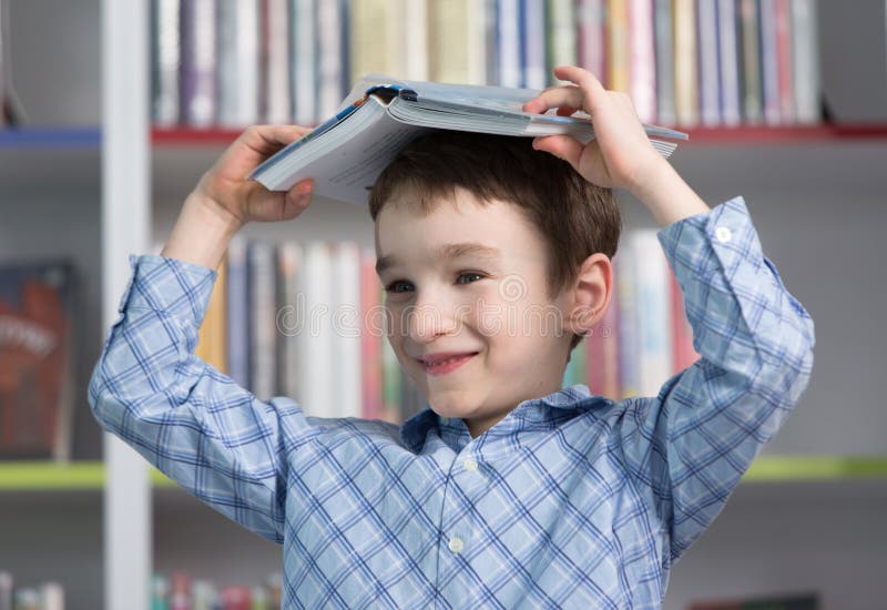 Cute Boy Reading Book in Library Stock Image - Image of library ...