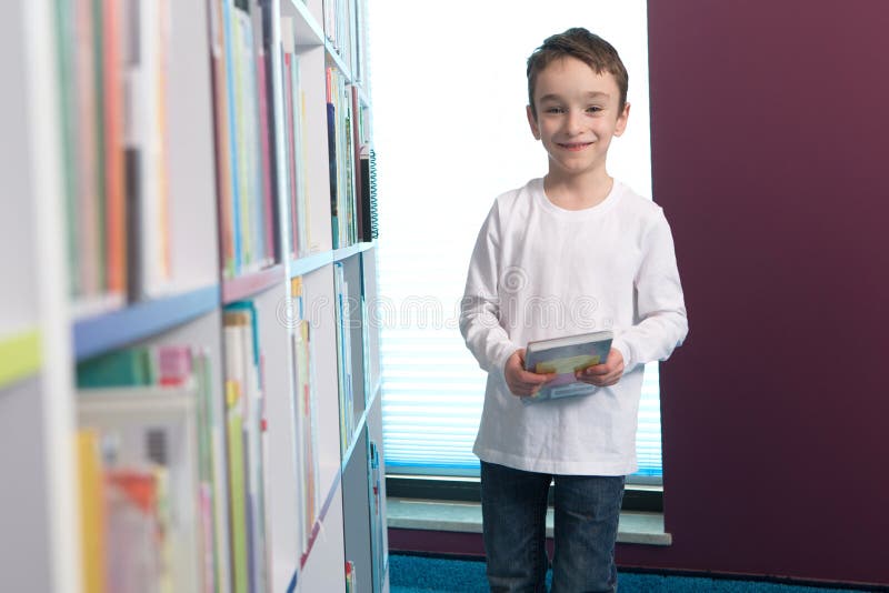 Cute Boy Reading Book in Library Stock Photo - Image of little ...