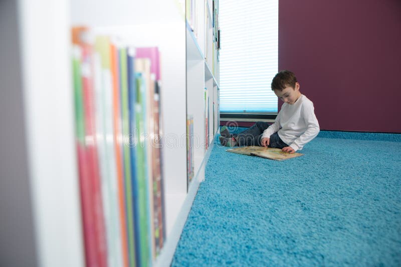 Cute Boy Reading Book in Library Stock Photo - Image of caucasian, kids ...