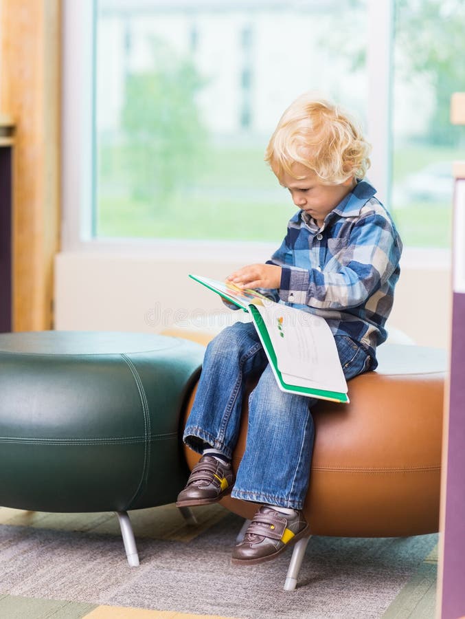 Cute Boy Reading Book in School Library Stock Photo - Image of book ...