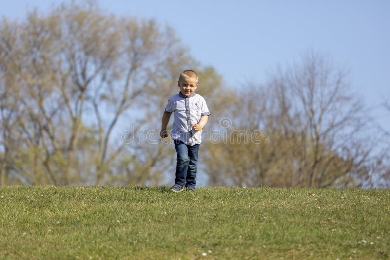Cute Boy Running Across Grass Und Smiling Stock Image - Image of ...