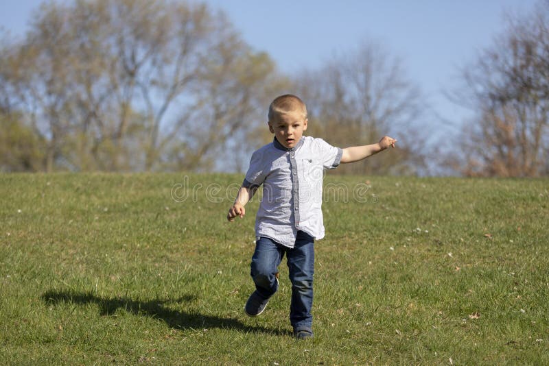 Cute Boy Running Across Grass Und Smiling Stock Photo - Image of ...