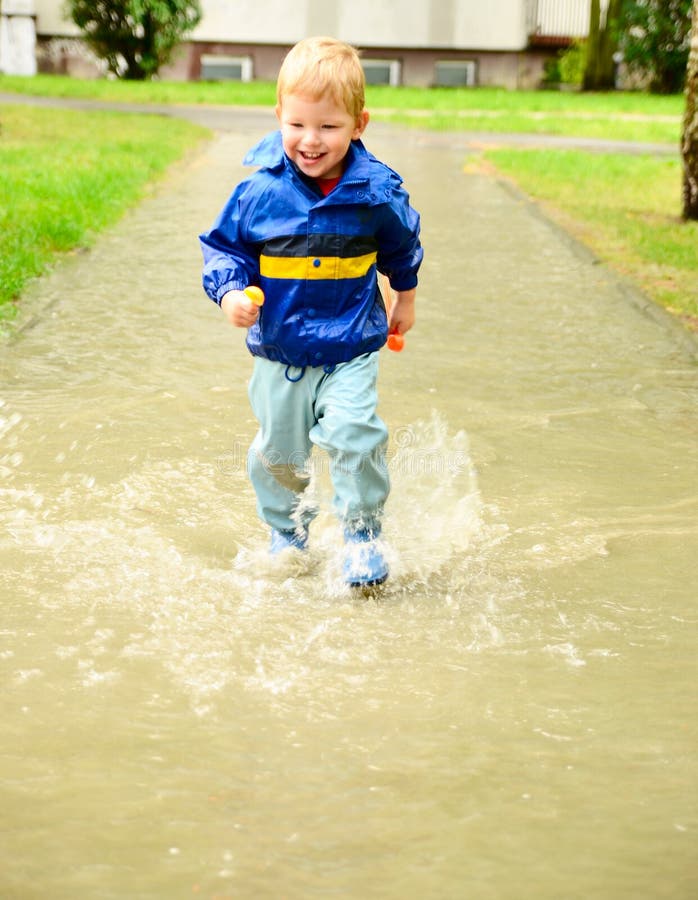 Happy Children in Water-proof Clothes Running through the Puddle after ...