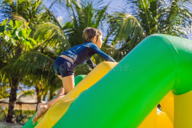 Cute Boy Runs an Inflatable Obstacle Course in the Pool Stock Image ...