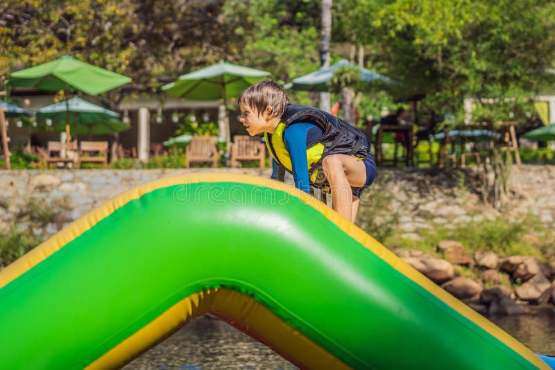 Cute Boy Runs an Inflatable Obstacle Course in the Pool Stock Image ...