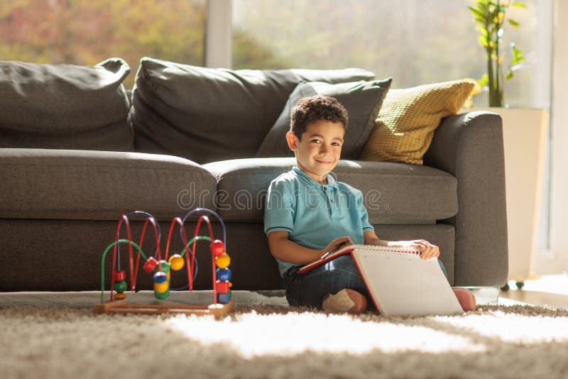 Cute Boy Sitting on a Carpet at Home Stock Photo - Image of cute, male ...