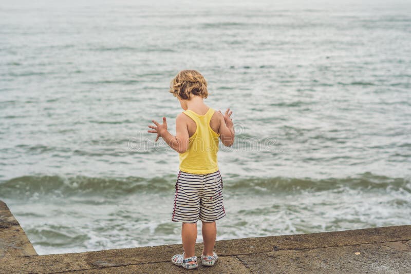 Cute Boy Stands on the Shore Watching the Ocean Waves Stock Image ...