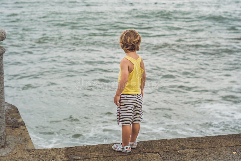 Cute Boy Stands on the Shore Watching the Ocean Waves Stock Image ...