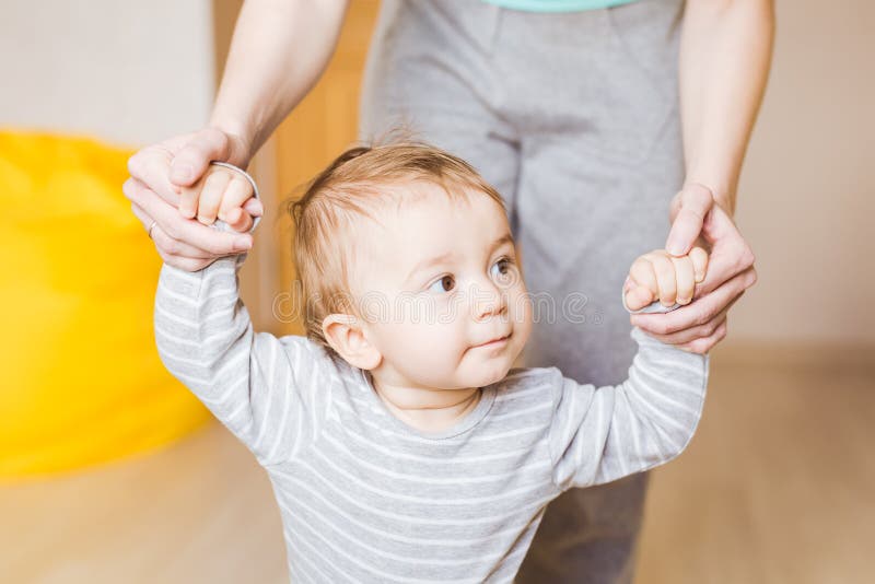 Cute Boy Taking First Steps Holding Mother`s Hands. Stock Photo - Image ...