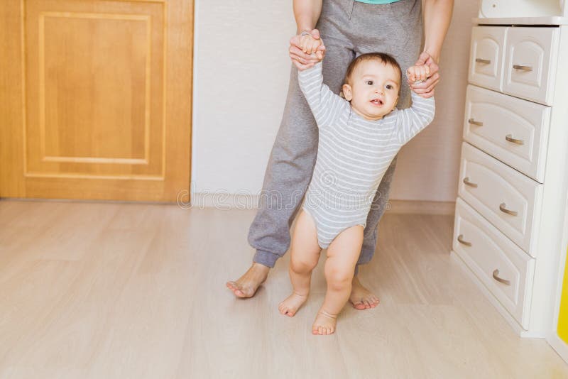 Cute Boy Taking First Steps Holding Mother`s Hands. Stock Photo - Image ...