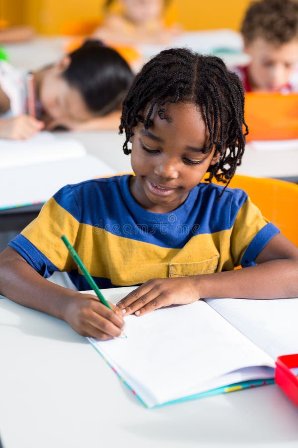 Cute boy writing on book stock image. Image of focus - 77703127