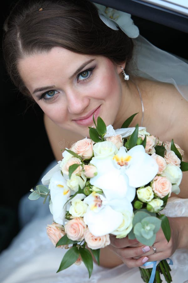 Cute Bride with a Bouquet in Her Hand in a Car in the Back Seat Stock ...