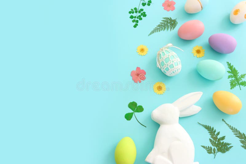 Cute Bunny Next To Easter Colorful Eggs Over Blue Pastel Background ...
