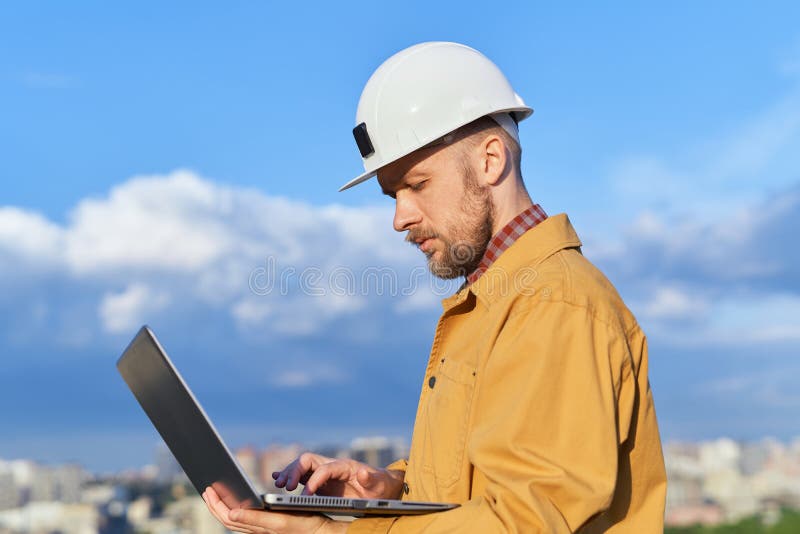 Technician Using Laptop at Construction Site, Urban Skyline Stock Photo ...