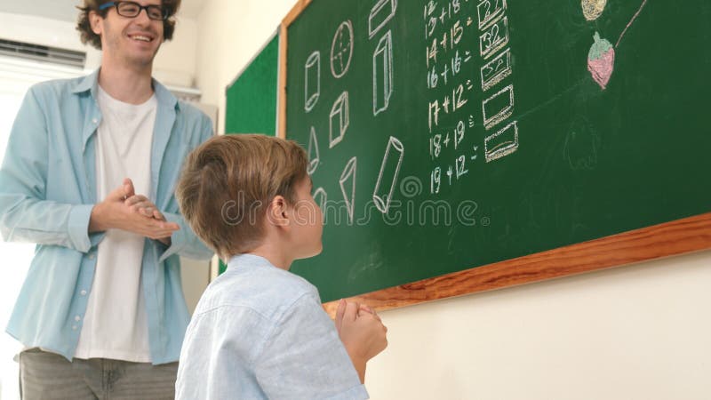 Cute Caucasian Boy Writing Answer at Blackboard and Standing at Class ...