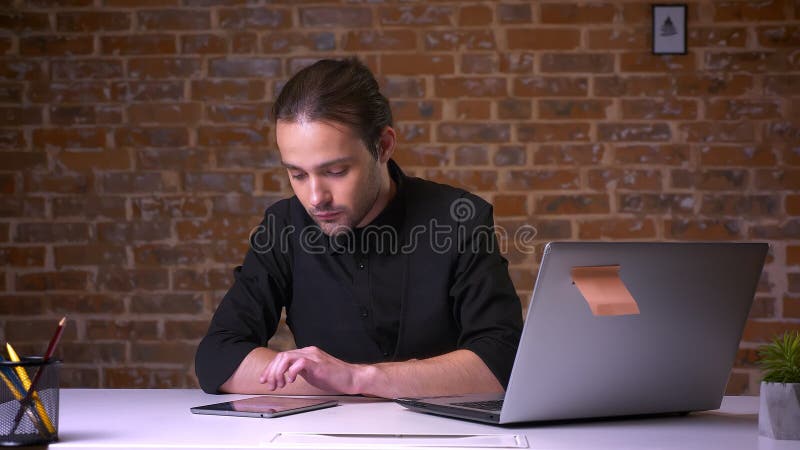 Cute Caucasian Guy Scrolling His Tablet while Sitting at His Working ...