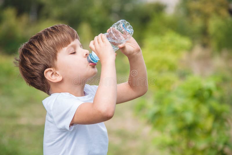 Cute Child Drinks Water from a Bottle on the Street in Summer Stock ...