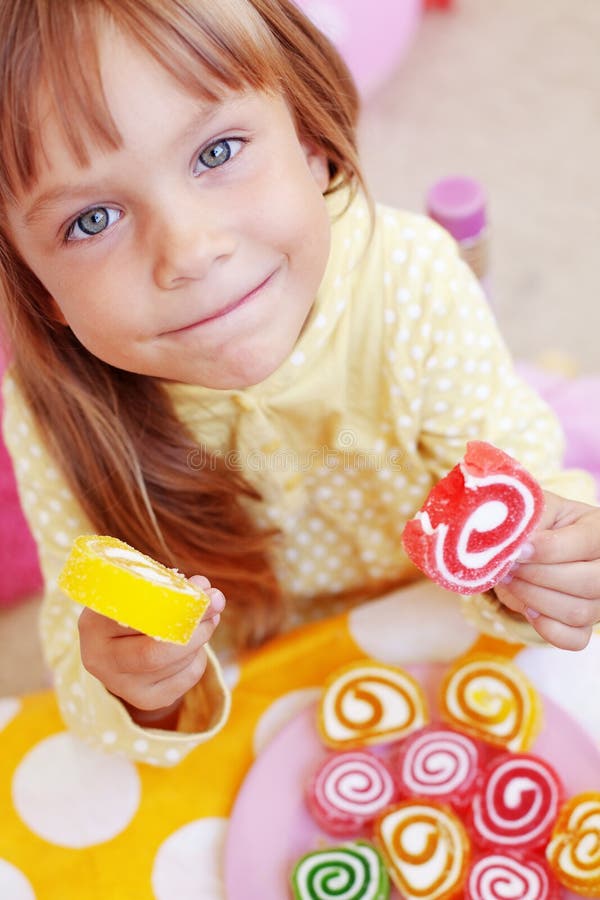 Cute child eating candies stock photo. Image of holding - 15867410