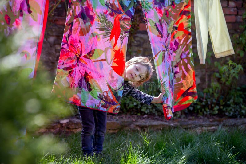 Cute Child, Hiding Behind Washed Bed Sheets on the Cord Stock Photo ...