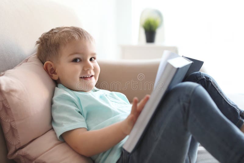 Cute Child Reading Book on Sofa Stock Photo - Image of development ...