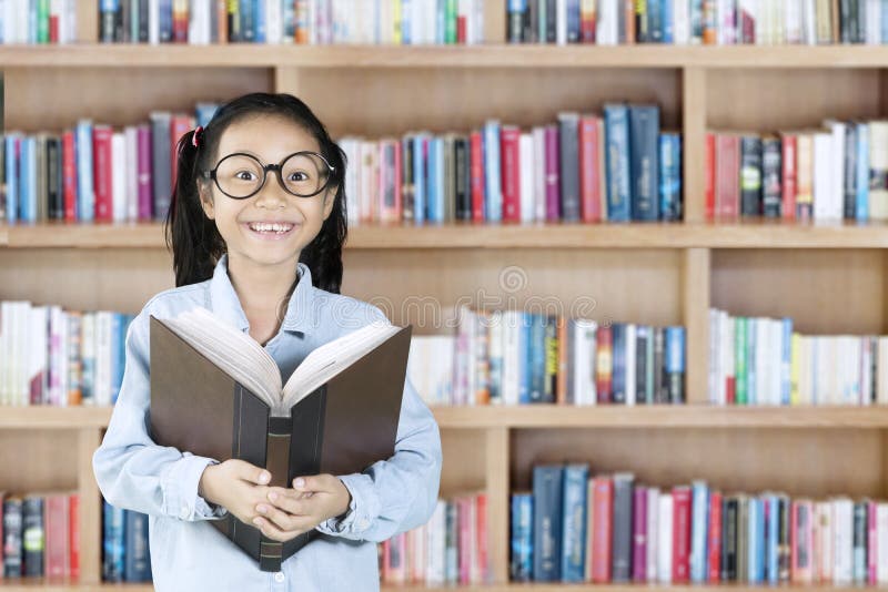 Cute Child Smiling with Book in Library Stock Image - Image of glasses ...