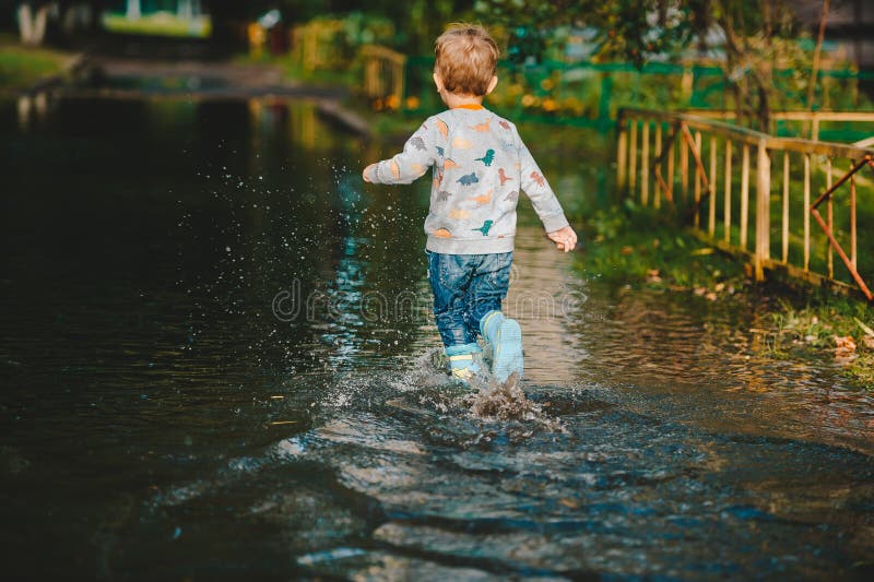 Cute Child Walking on Puddle after a Rain Stock Photo - Image of play ...