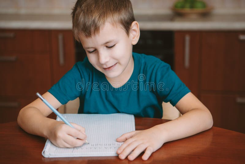 Cute Child Writing Letters in Notebook Sitting by Table Stock Image ...
